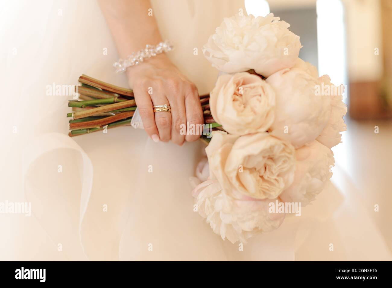 Bride with engagement ring on her finger, holding wedding bouquet of ...