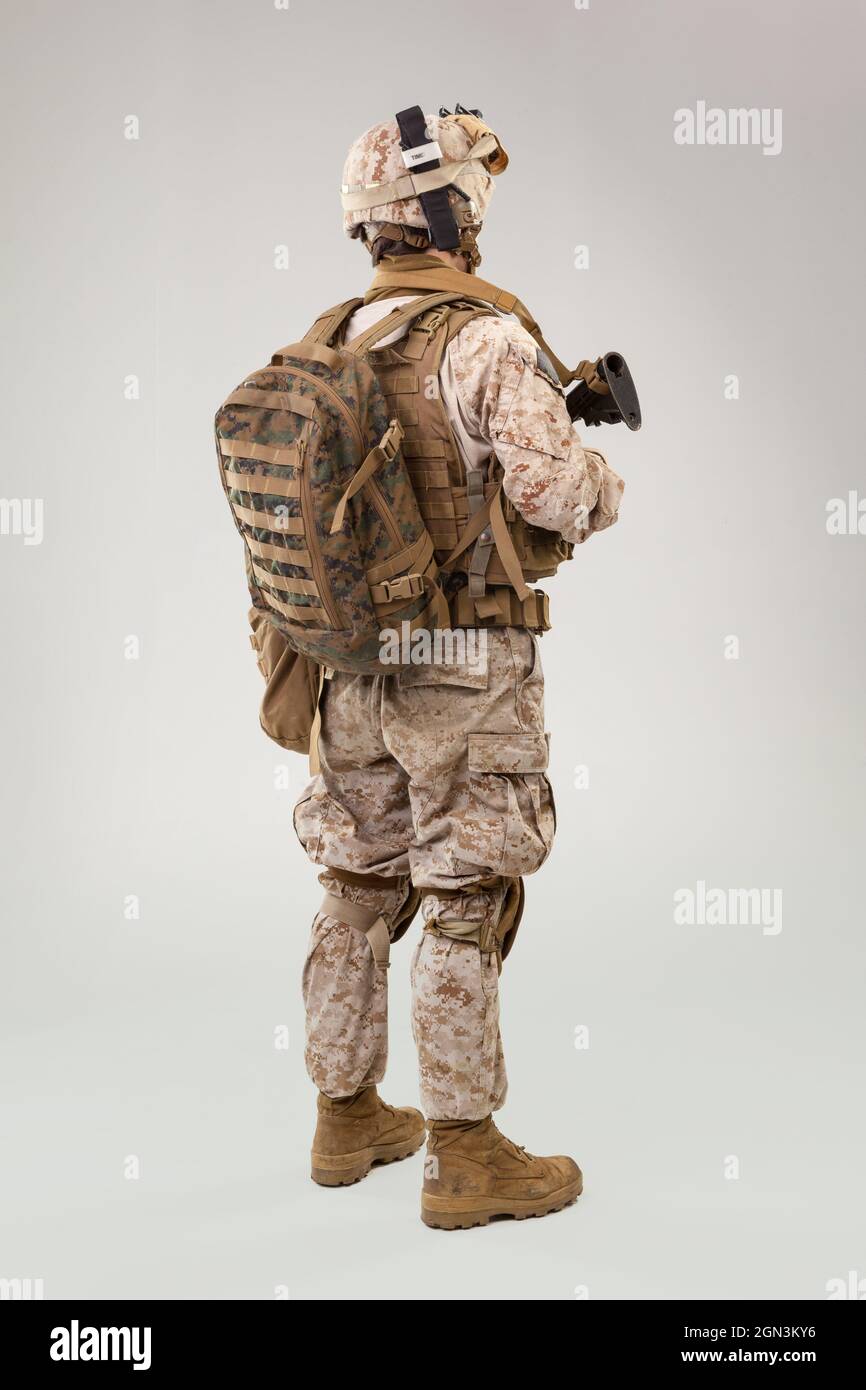 Portrait of a young American US Marine Corps soldier over grey ...