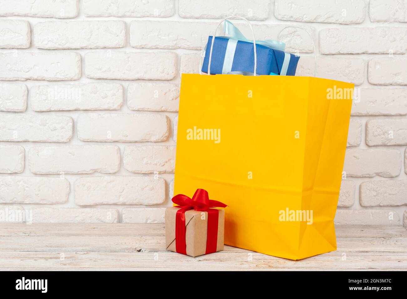 Decorated gift box put against white brick wall Stock Photo - Alamy