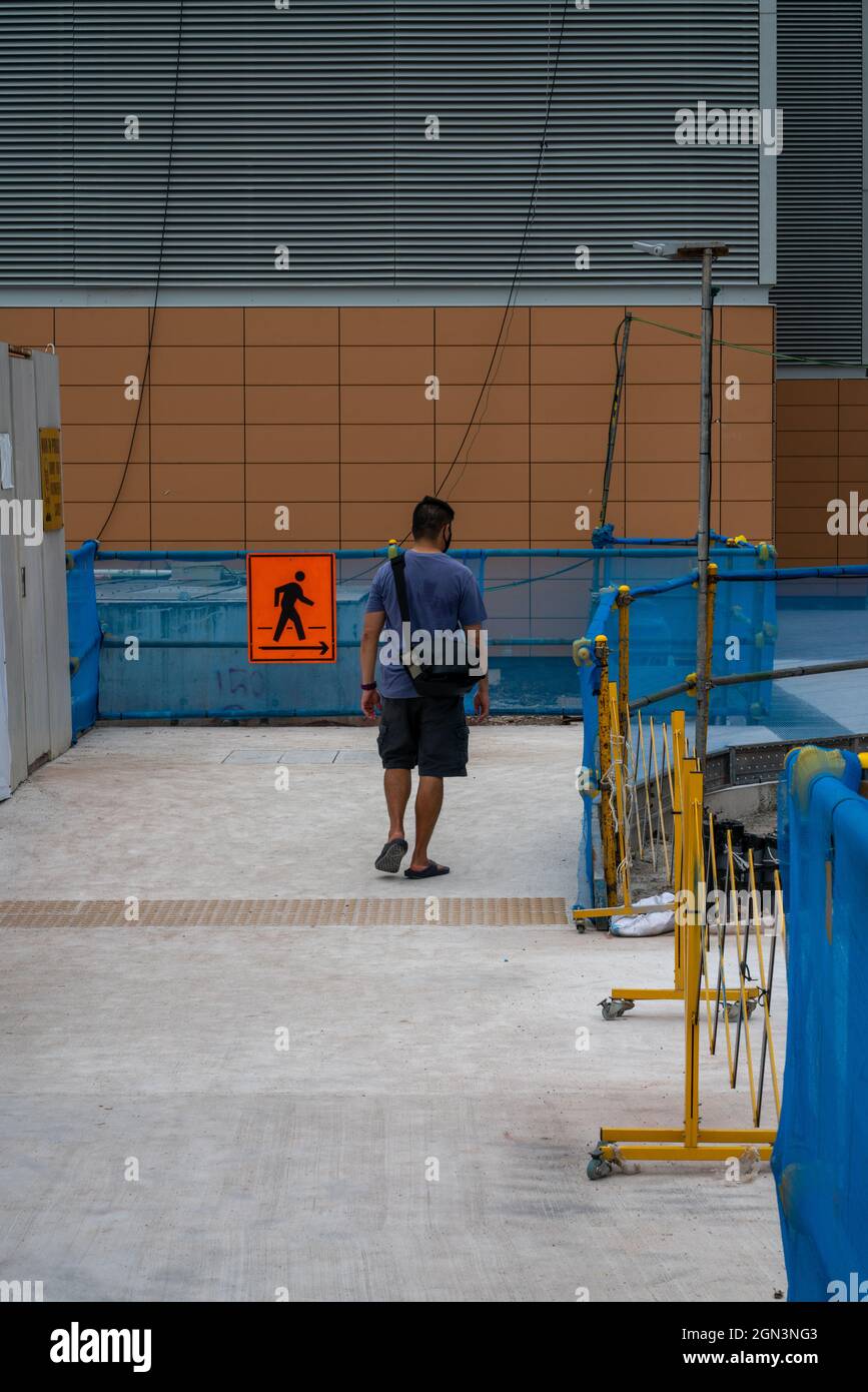 Chinese man walking at public walkway, construction ongoing, Singapore ...
