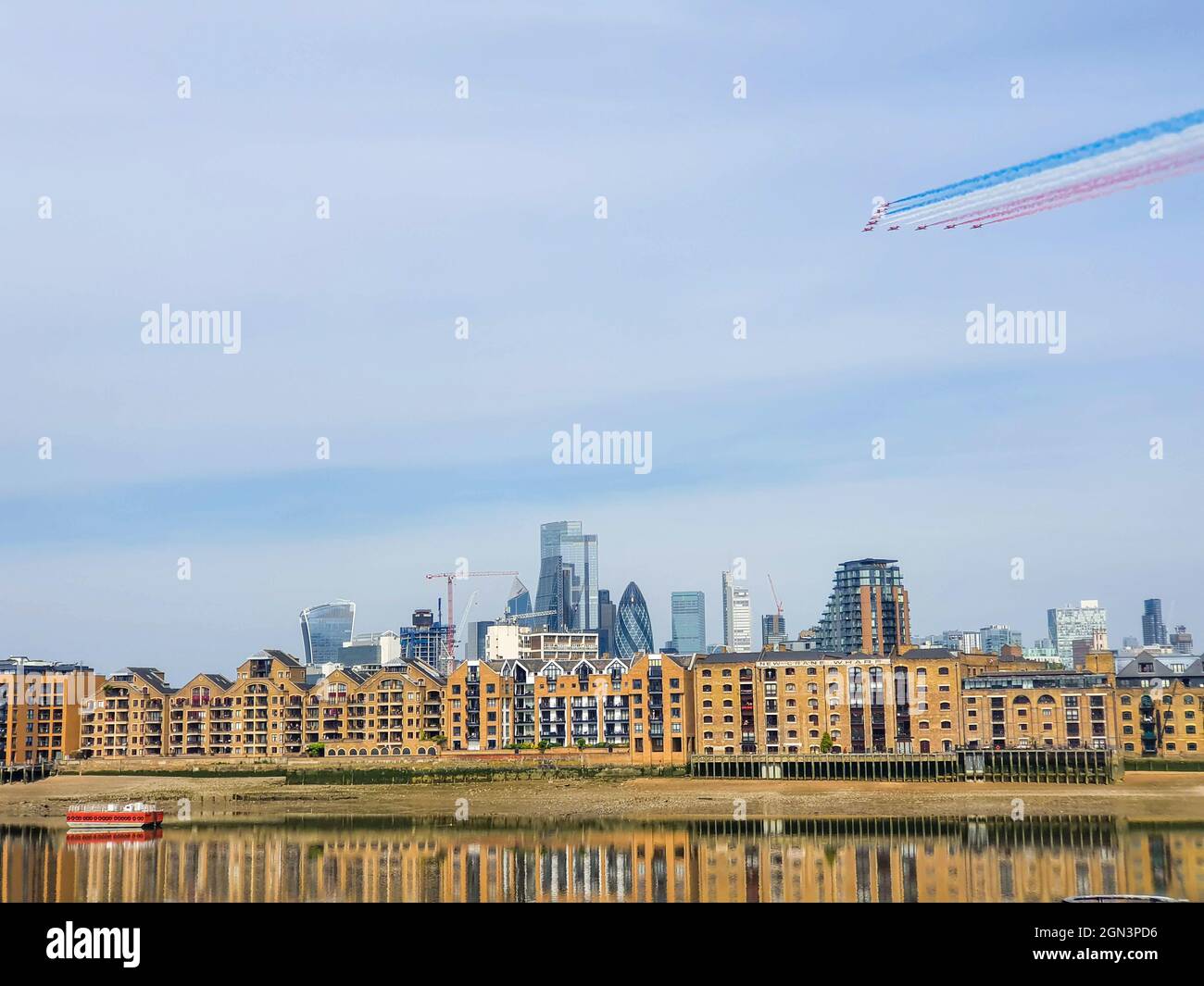 RAF Red Arrows fly over a still Thames and the City of London Stock ...