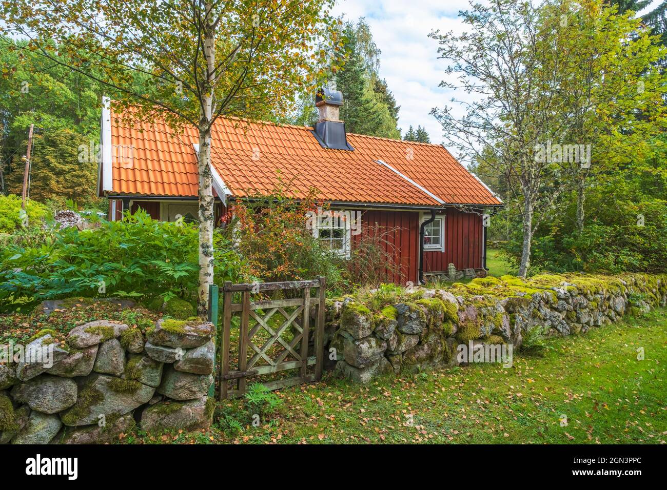 Idyllic red cottage with gate to the garden Stock Photo - Alamy
