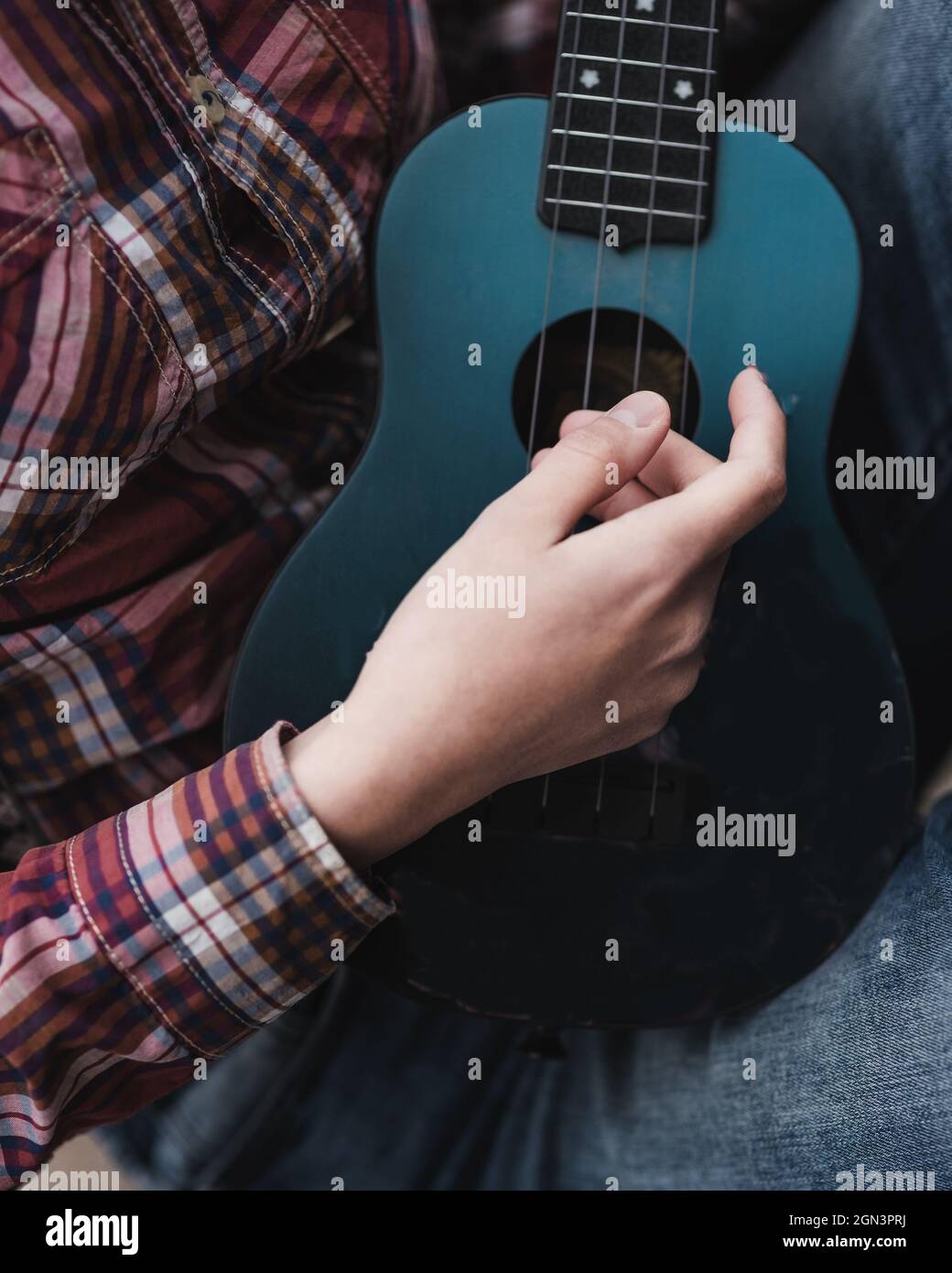 Young woman playing ukulele guitar Stock Photo - Alamy
