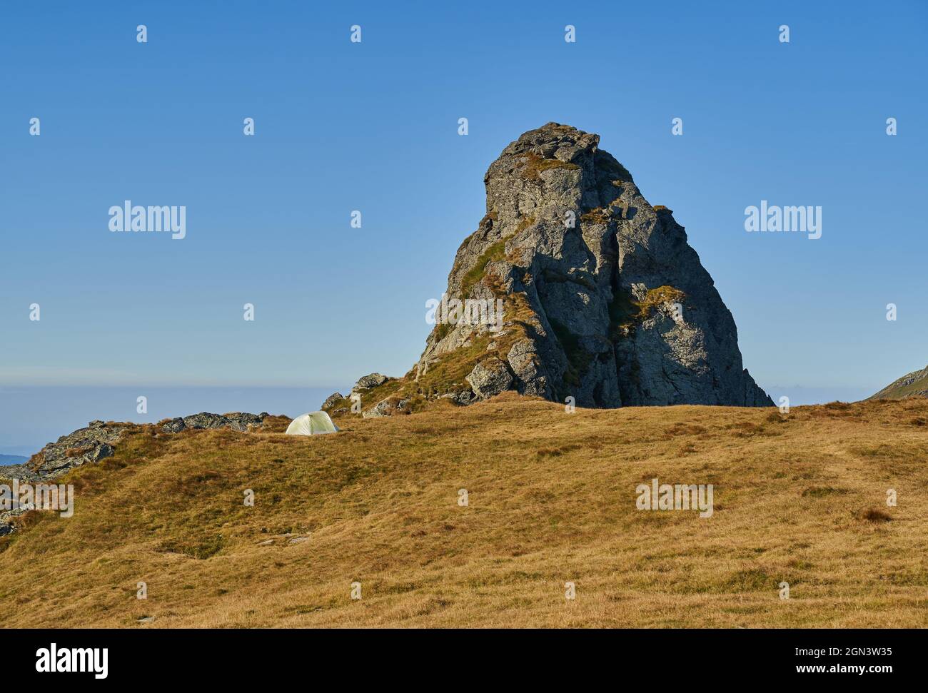 Tent by a huge rock formation in Fagaras mountains in Romania Stock ...