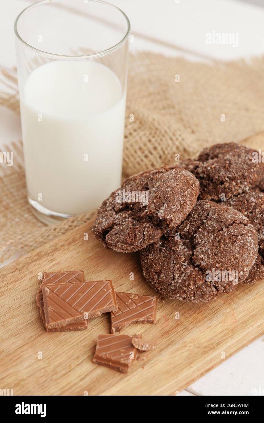 Milk glass and biscuit cookies with kitchen cloth on light background ...