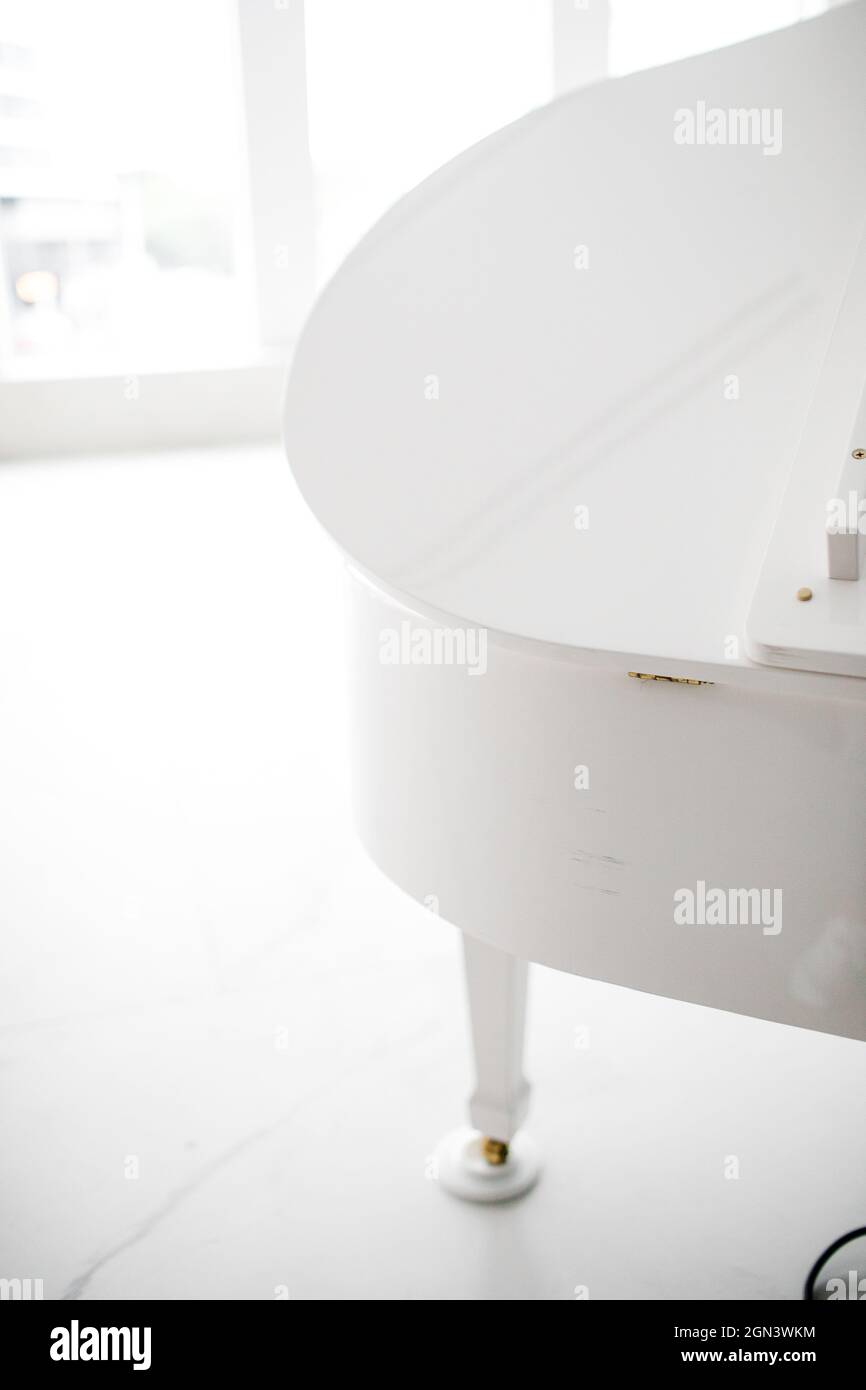 white Grand piano in a beautiful light interior Stock Photo - Alamy