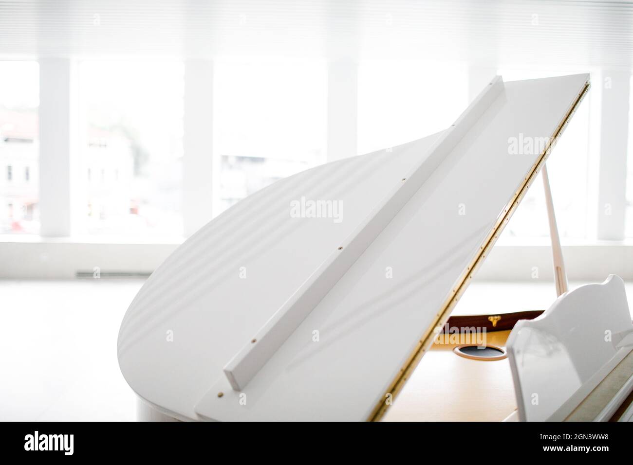 white Grand piano in a beautiful light interior Stock Photo - Alamy