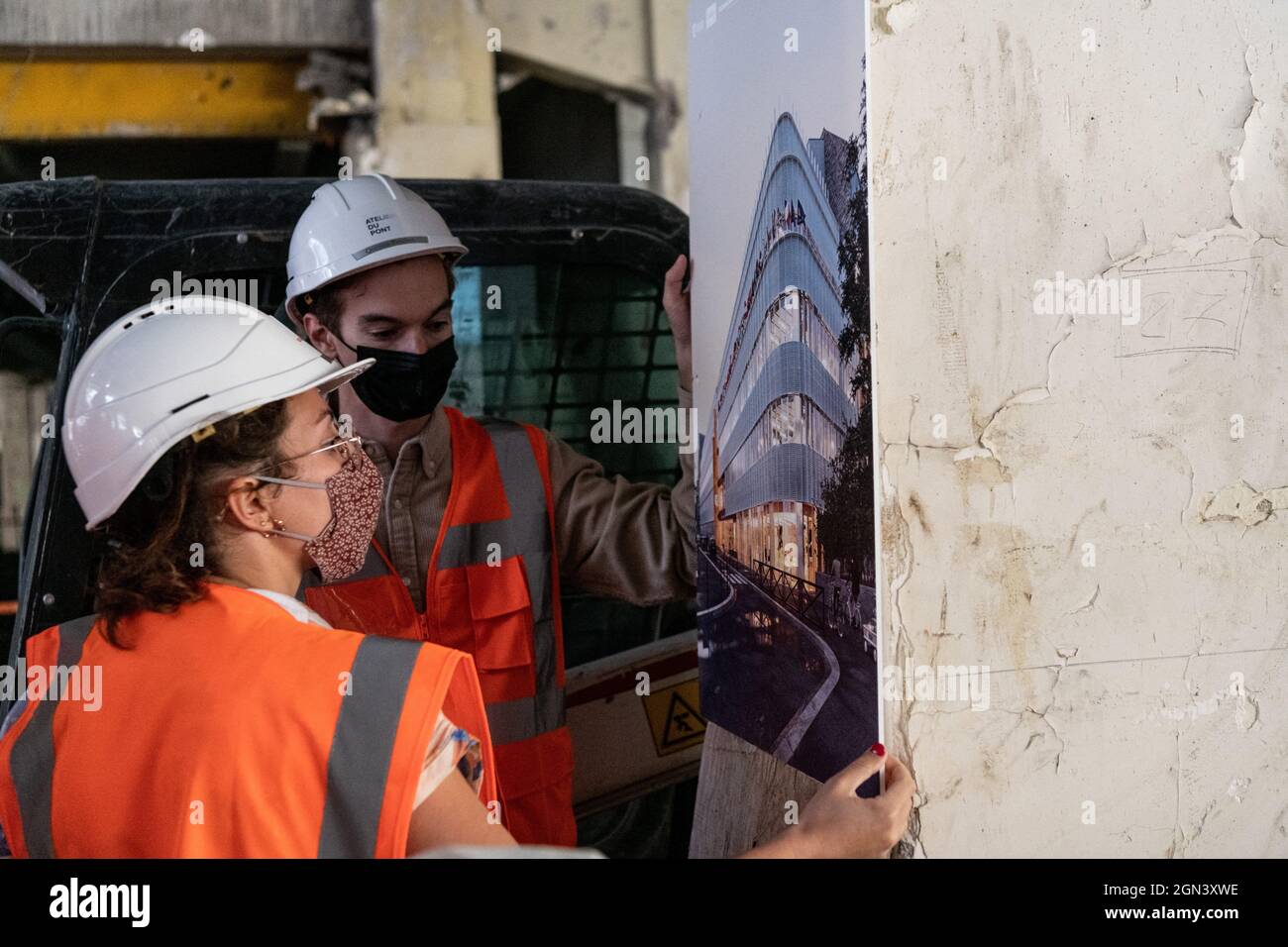 Workers attach a picture of the future headquarters in the location of ...
