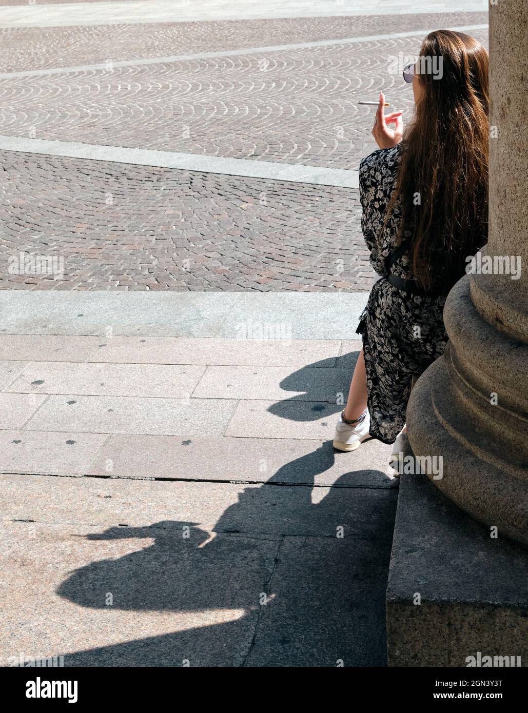 alone sitting fashion girl with her shadow smoking cigarette in Milan ...