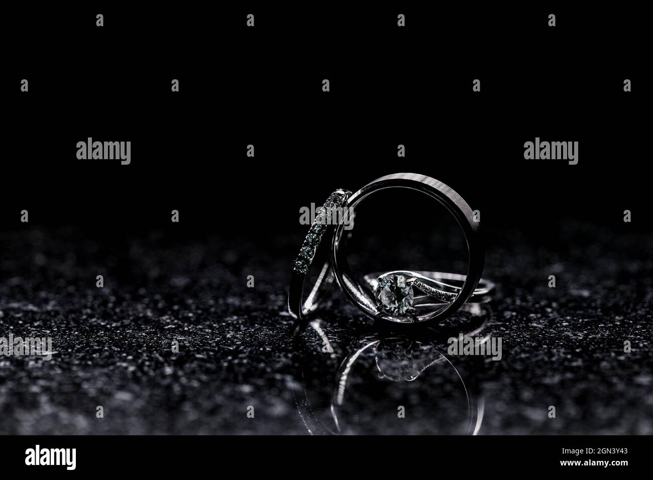 wedding rings with diamonds on black background Stock Photo - Alamy