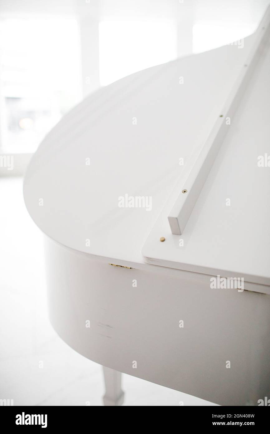 white Grand piano in a beautiful light interior Stock Photo - Alamy
