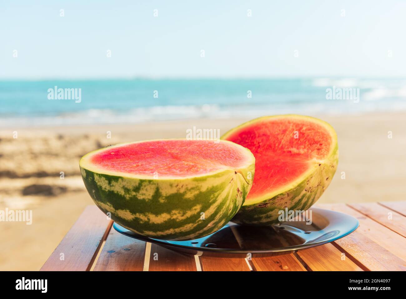 Watermelon on a plate on summer beach Stock Photo - Alamy