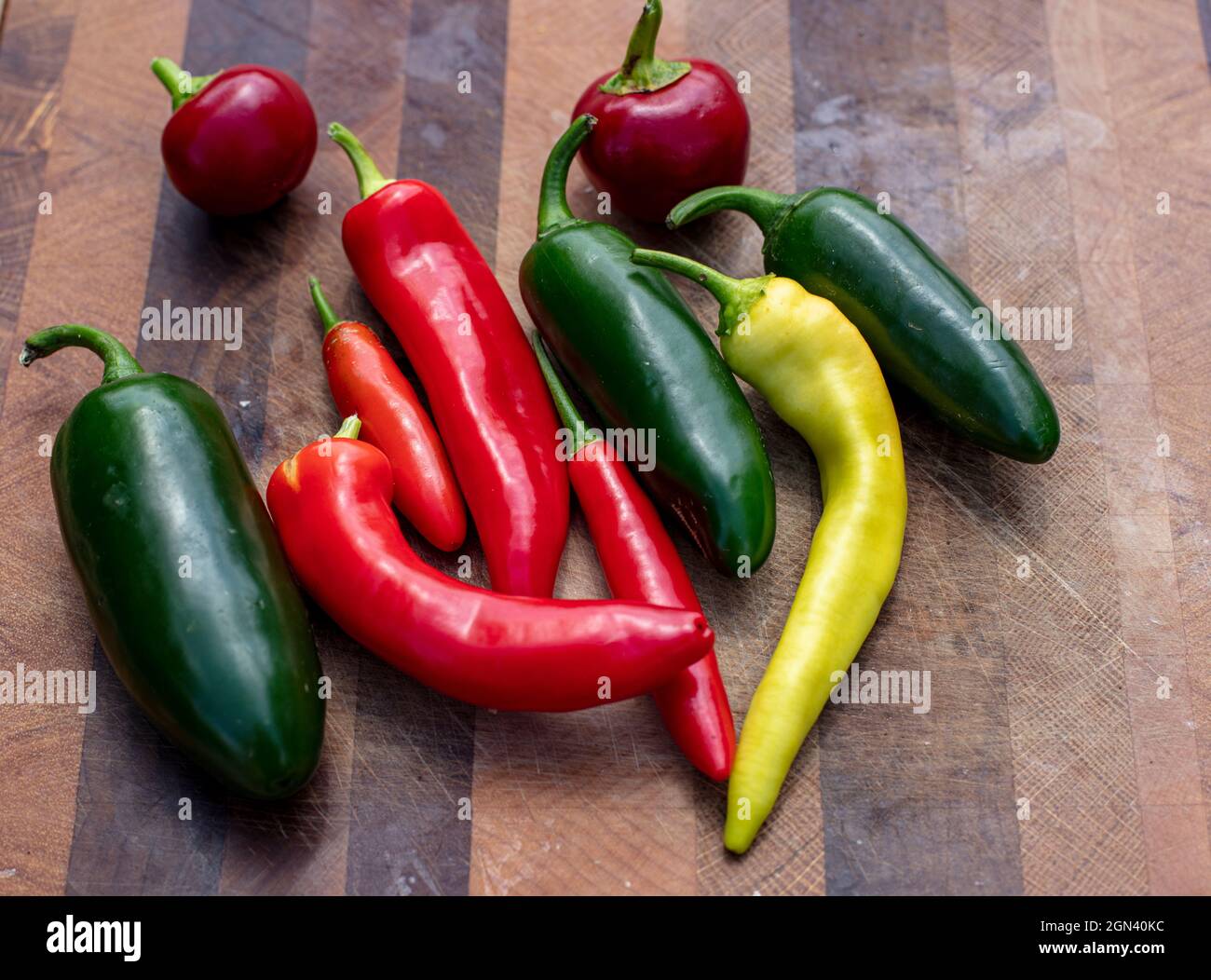 Colorful hot peppers arranged on a cutting board Stock Photo - Alamy