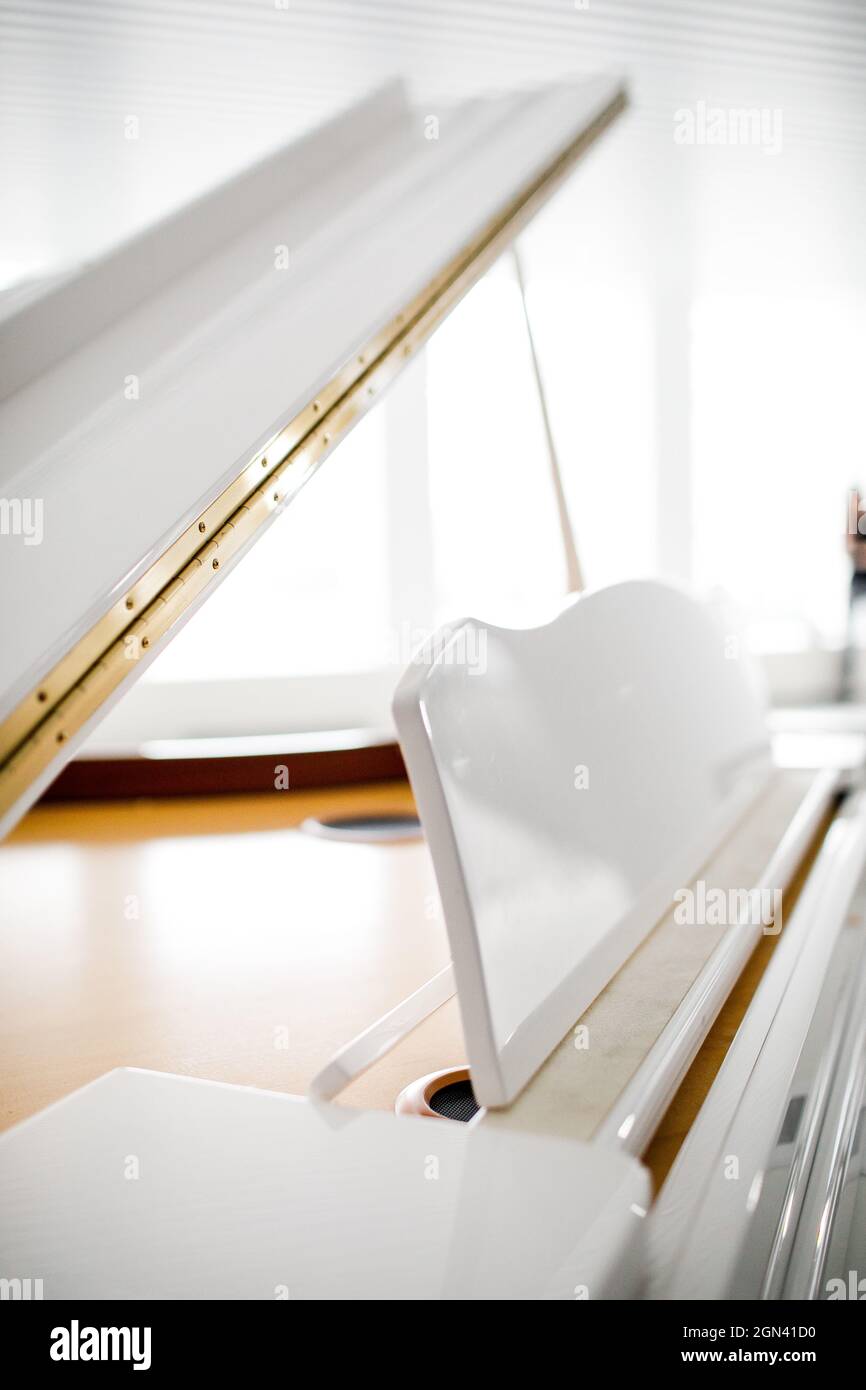 white Grand piano in a beautiful light interior Stock Photo - Alamy