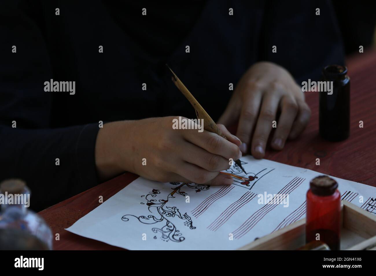 Closeup of the person drawing beautiful patterns on the manuscript ...