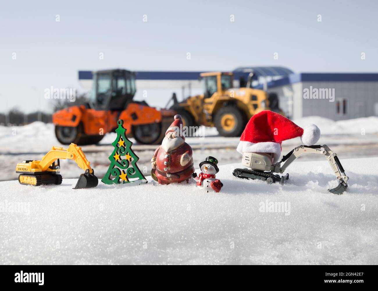 composition of small toy excavators, souvenir snowman, santa claus in a ...