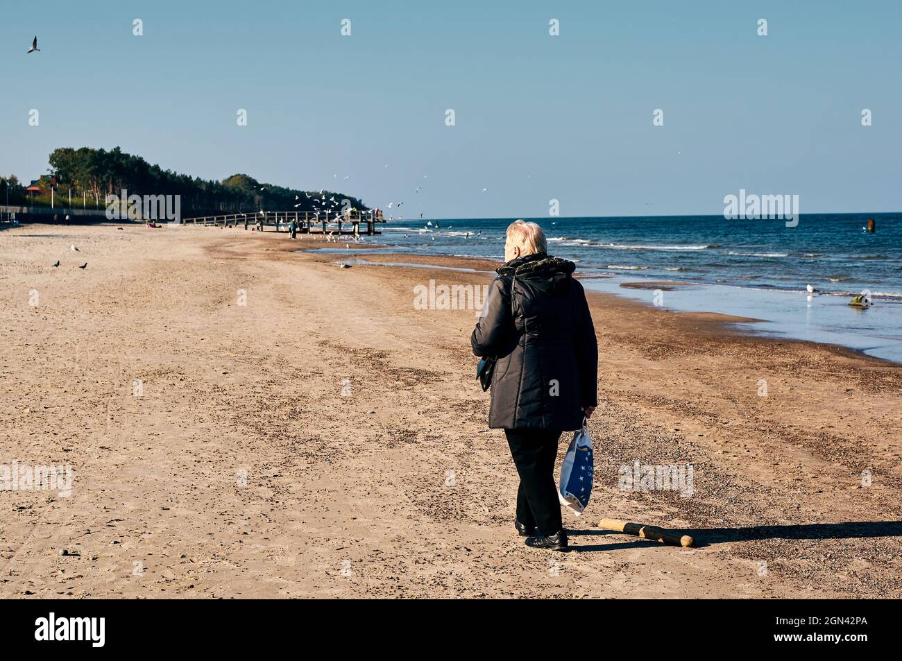 SARBINOWO, POLAND - Oct 16, 2017: A woman walking on sand along the ...