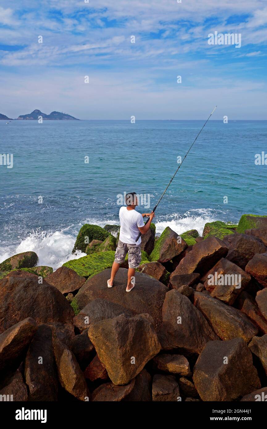 RIO DE JANEIRO, BRAZIL - NOVEMBER 14, 2015: Young man fishing at Barra ...