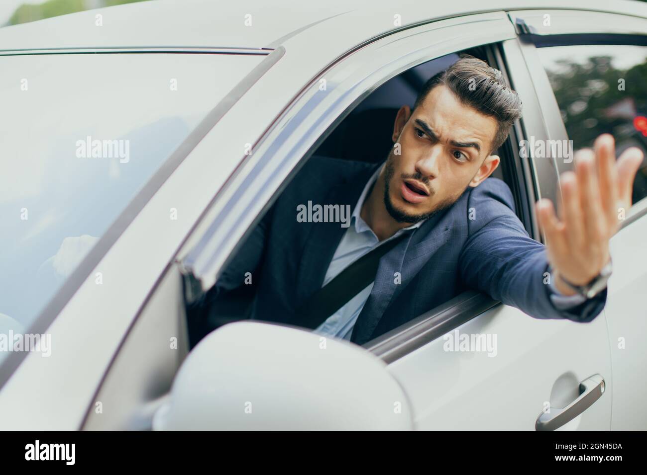 Irritated middle-eastern businessman driving auto, fighting on road ...