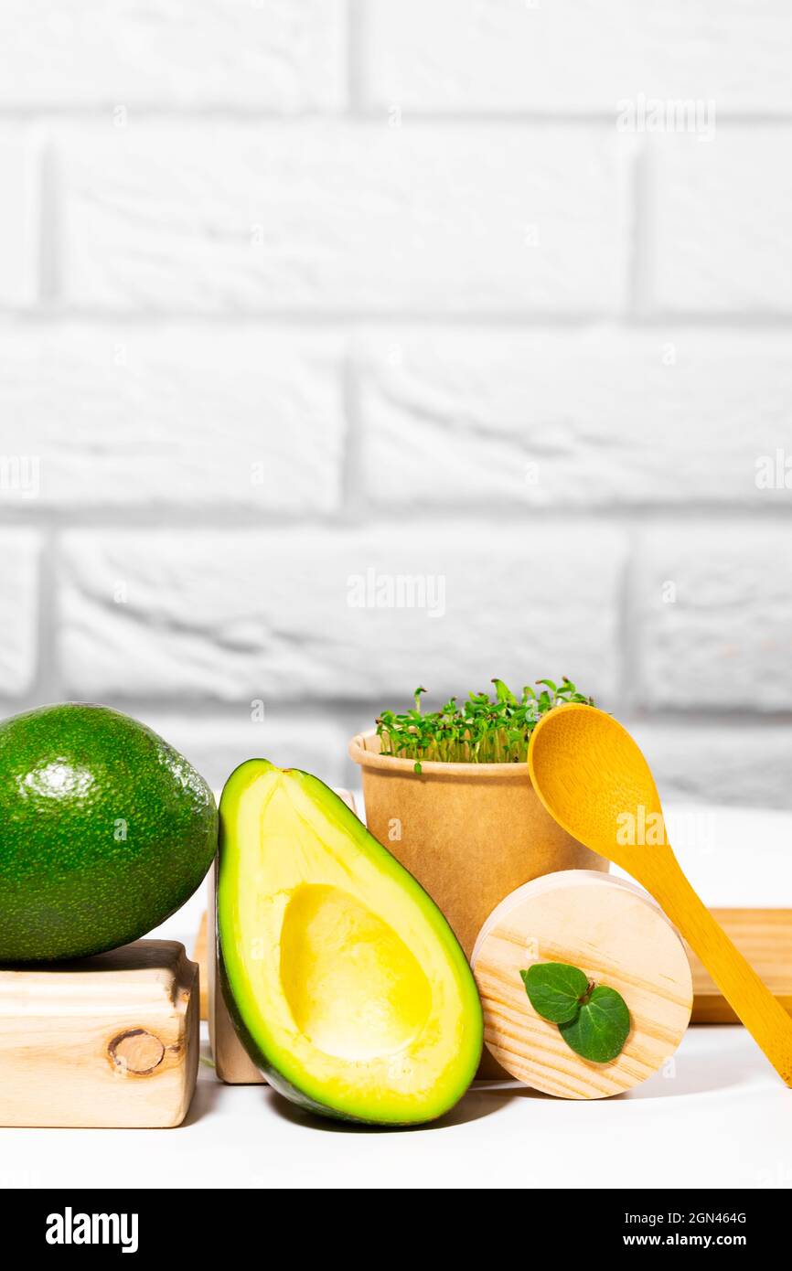 Creative still life with avocado, micro green and spoon on white ...