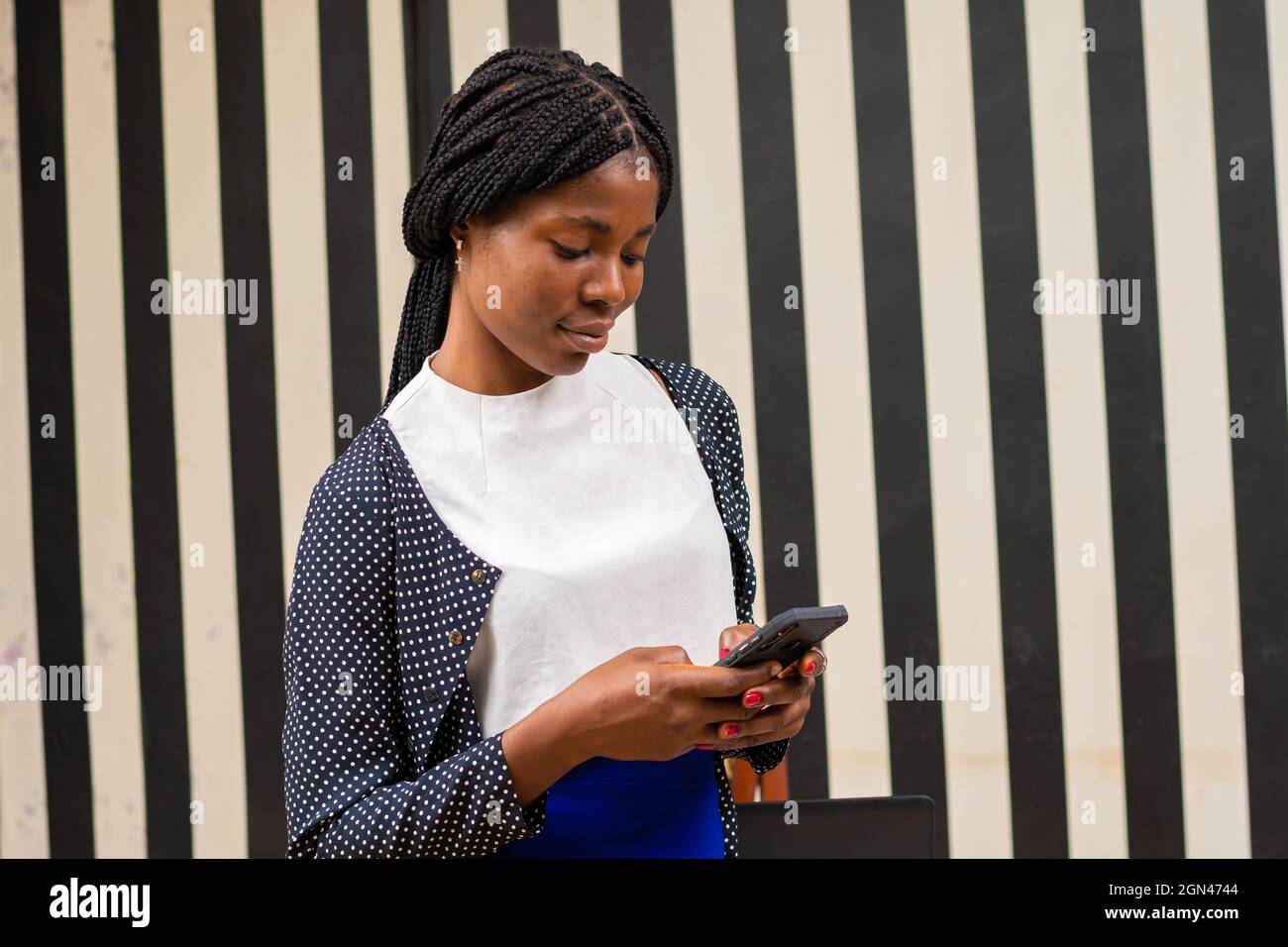 Woman in a business outfit checking her phone Stock Photo - Alamy