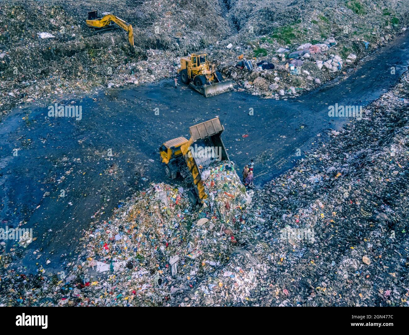 Aerial vie taked with a drone of trash collectors on a garbage deposit ...