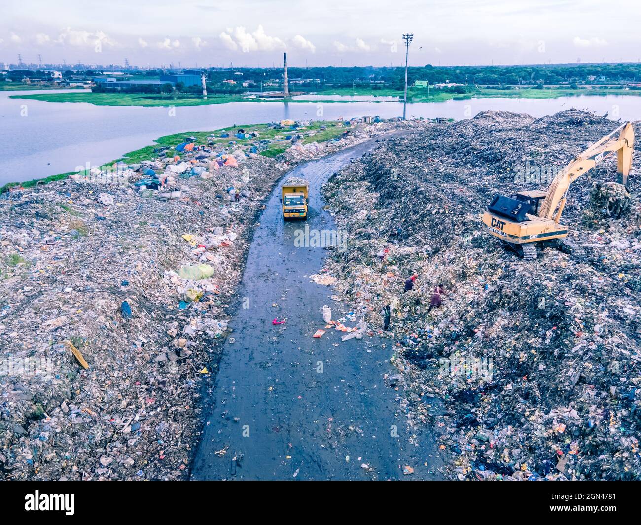Aerial vie taked with a drone of trash collectors on a garbage deposit ...