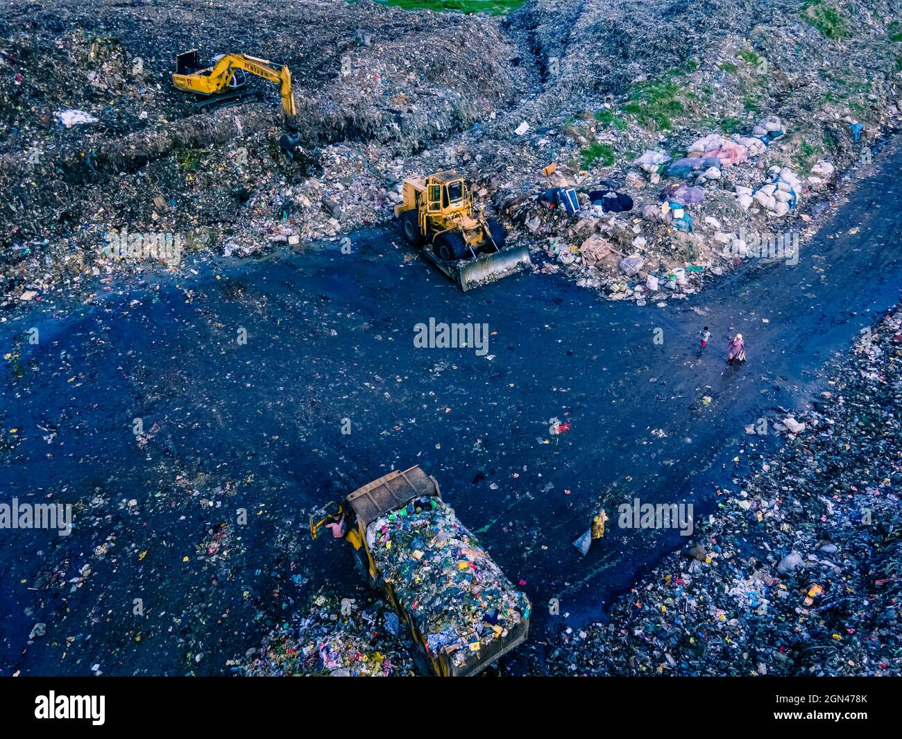 Aerial vie taked with a drone of trash collectors on a garbage deposit ...