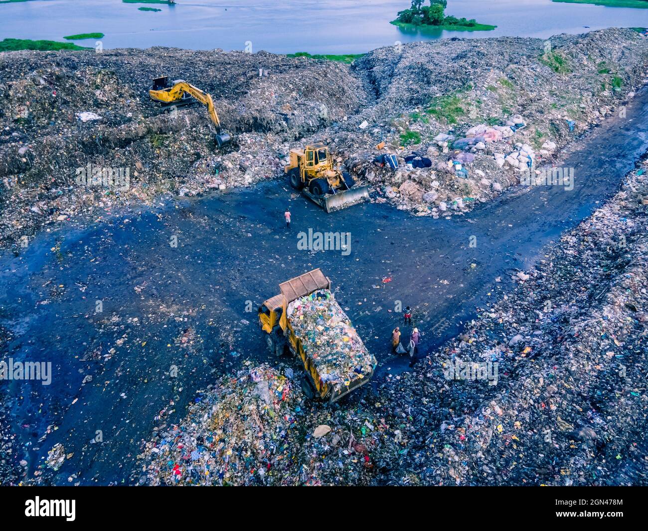 Aerial vie taked with a drone of trash collectors on a garbage deposit ...