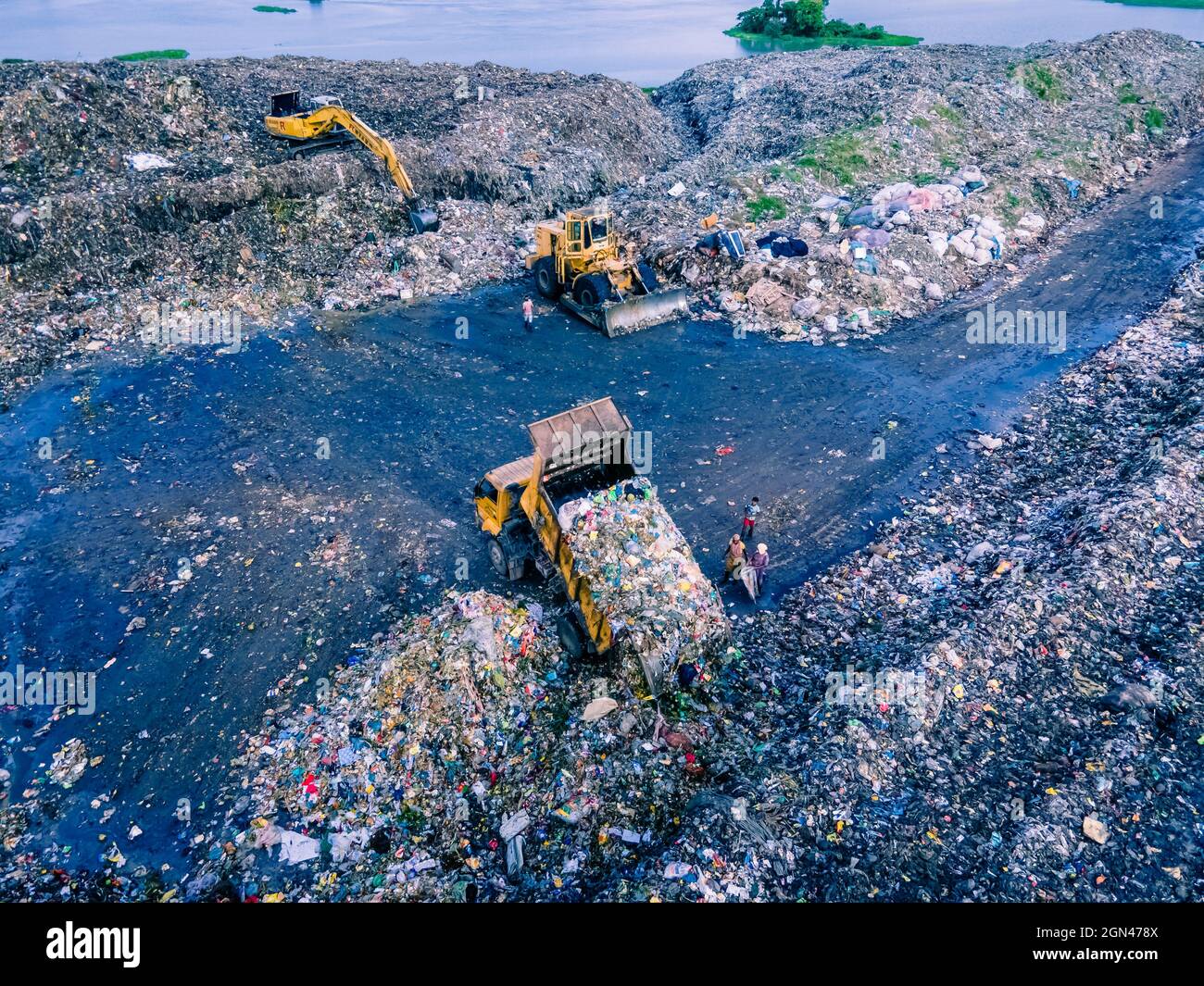 Aerial vie taked with a drone of trash collectors on a garbage deposit ...