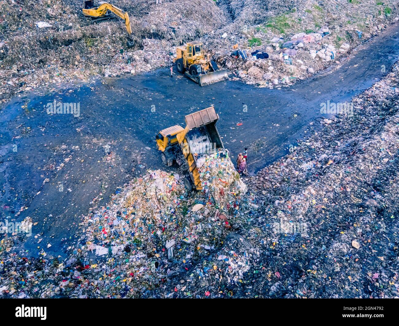 Aerial vie taked with a drone of trash collectors on a garbage deposit ...