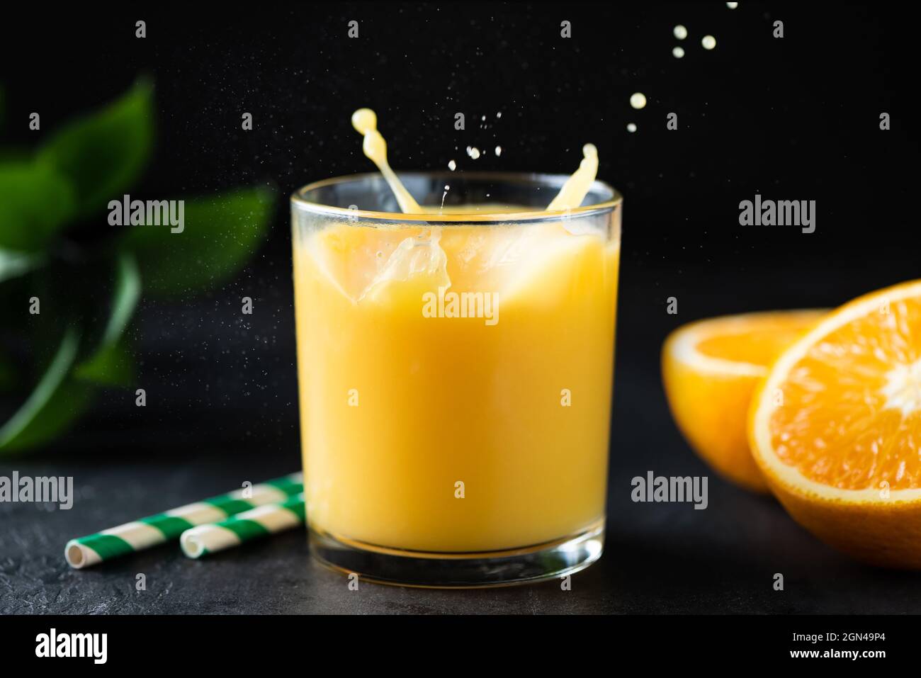 Orange juice with splash in a glass over black background Stock Photo ...