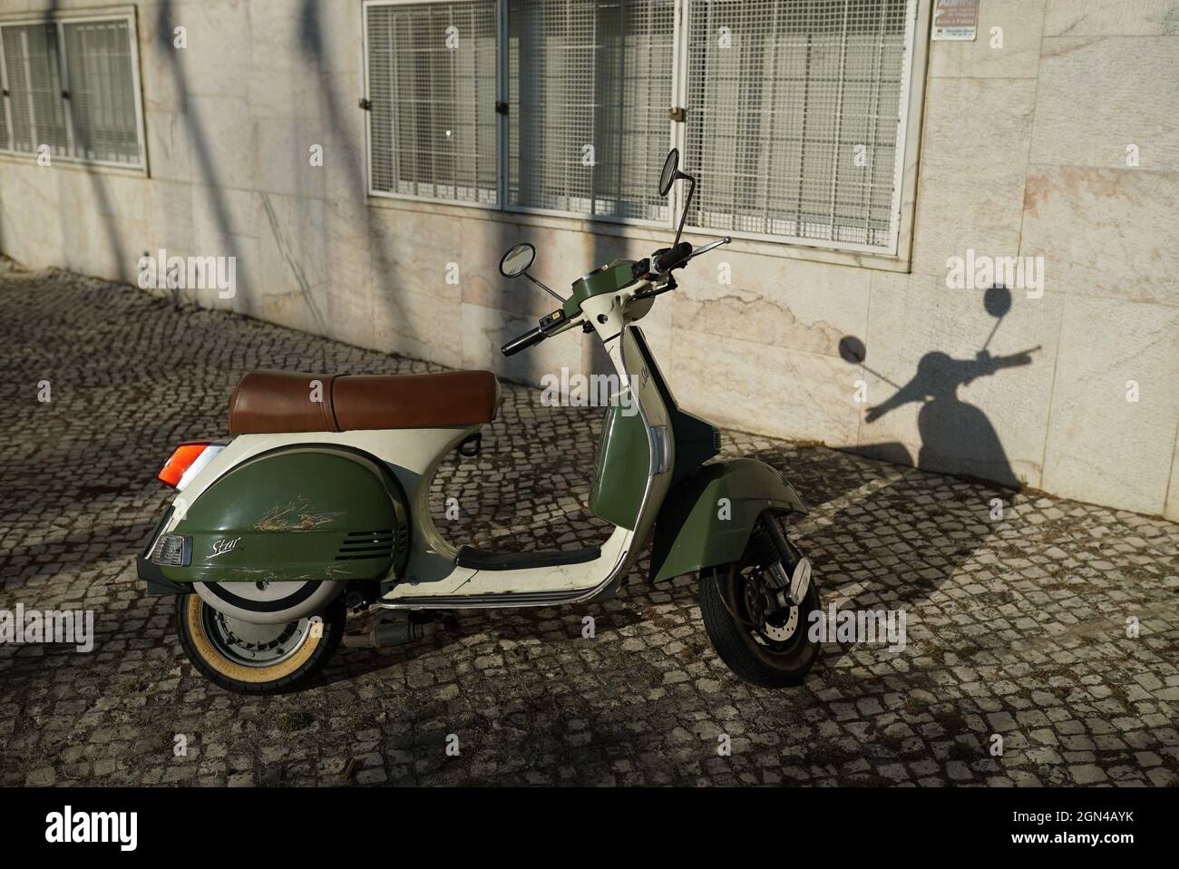 LISBON, PORTUGAL - Jul 23, 2021: A green "Vespa" motorbike parked at a ...