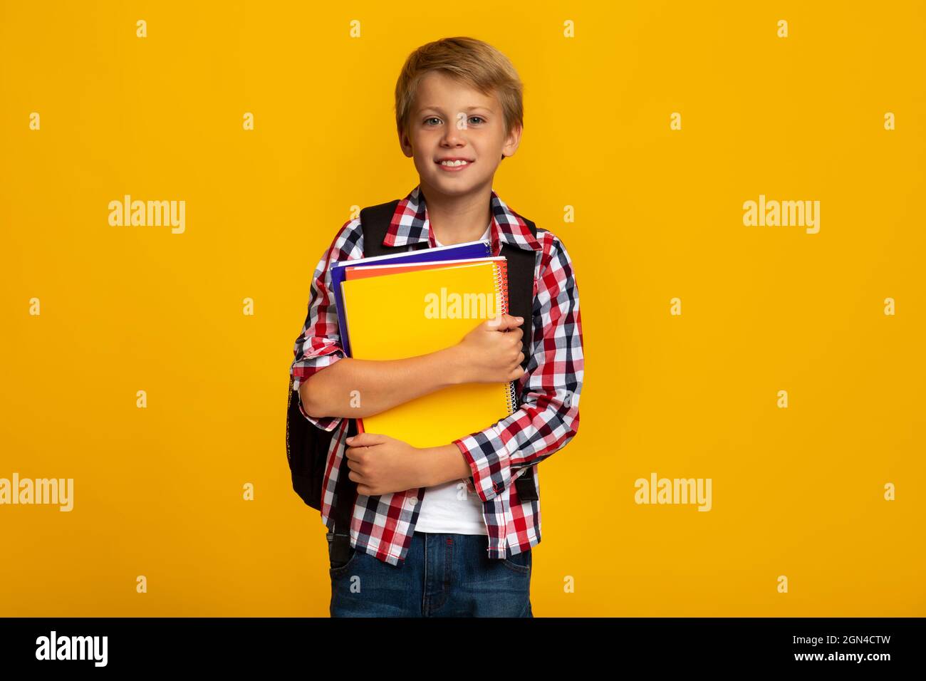 Smiling calm european young boy with books and notebooks ready to study ...