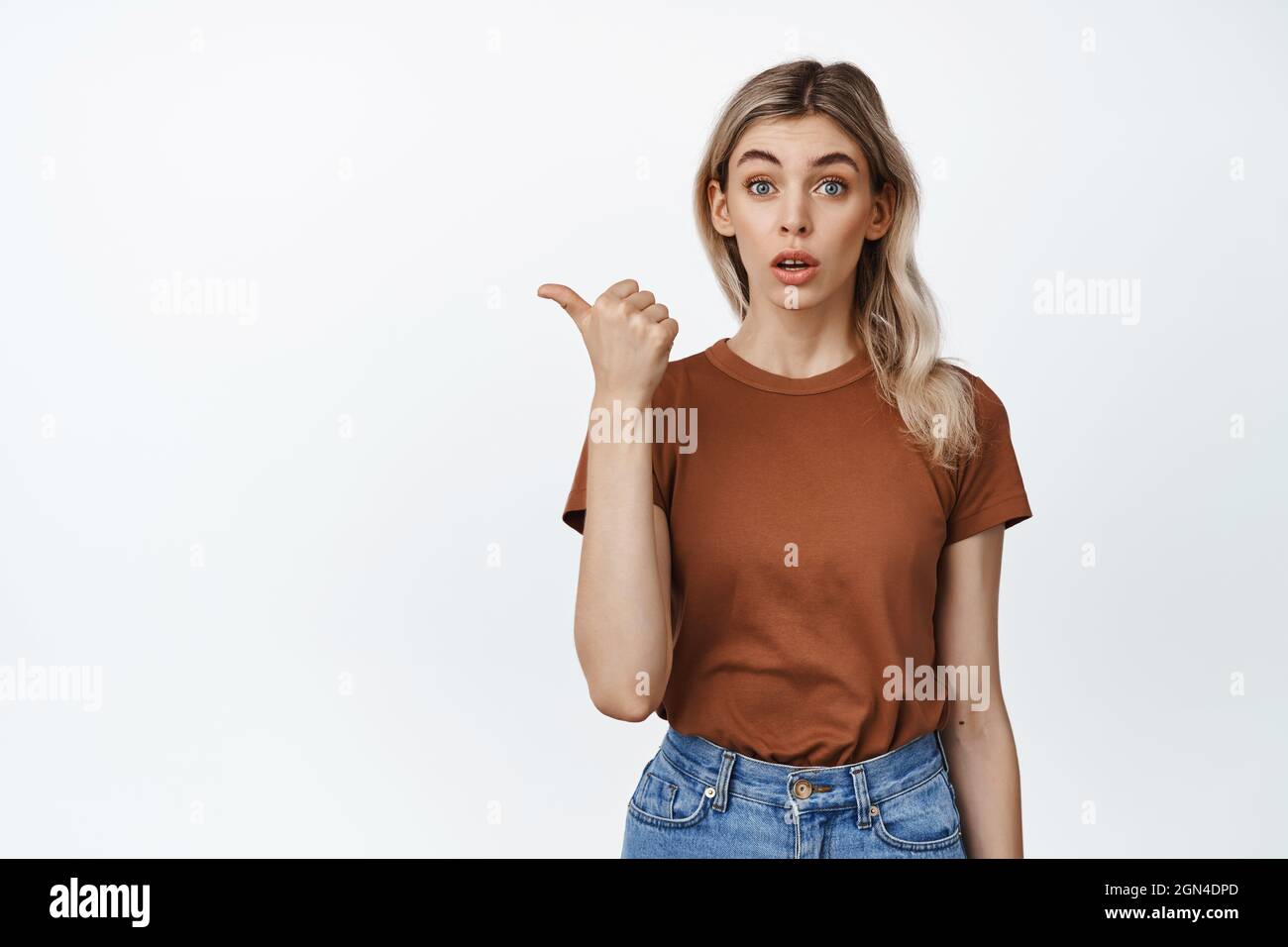 Young attractive girl with surprised face, looking curious and asking ...