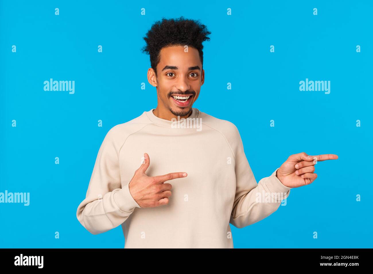 Impressed and excited handsome african-american male in white sweater ...