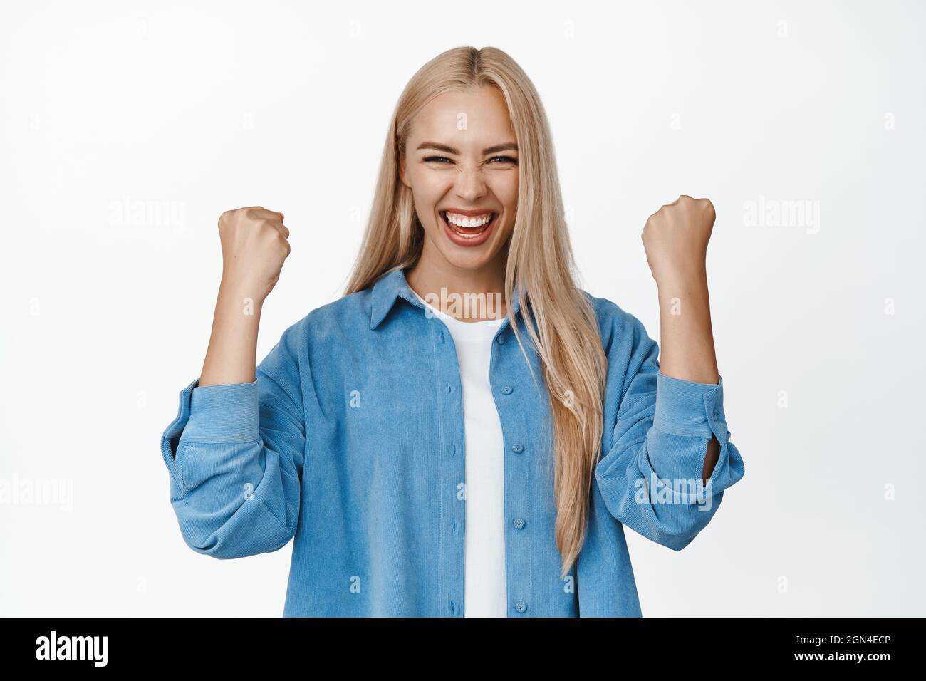 Happy blond woman winning and celebrating, making power encouragement ...