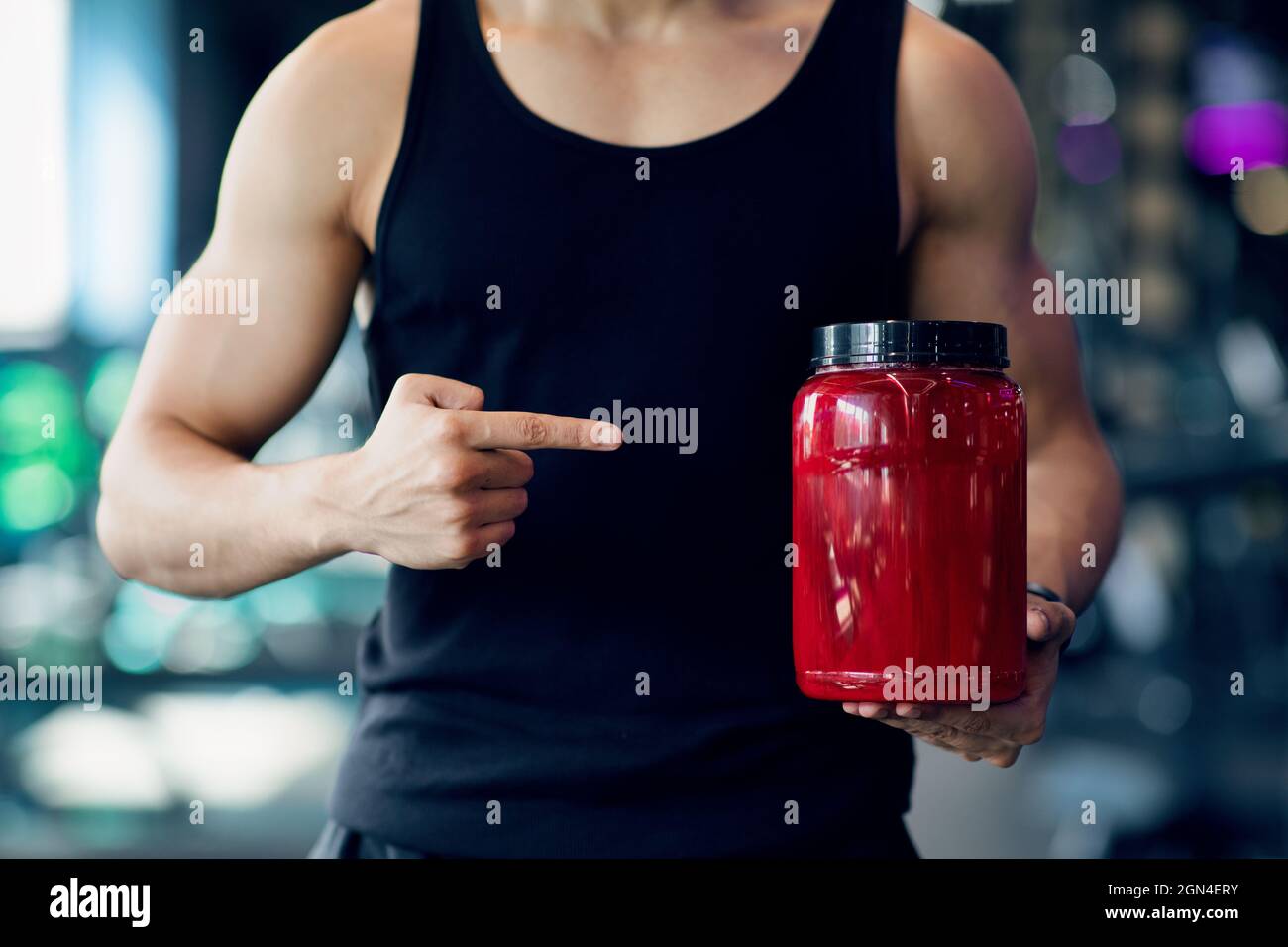 Bodybuilding Supplements. Muscular Man Pointing At Red Container With ...