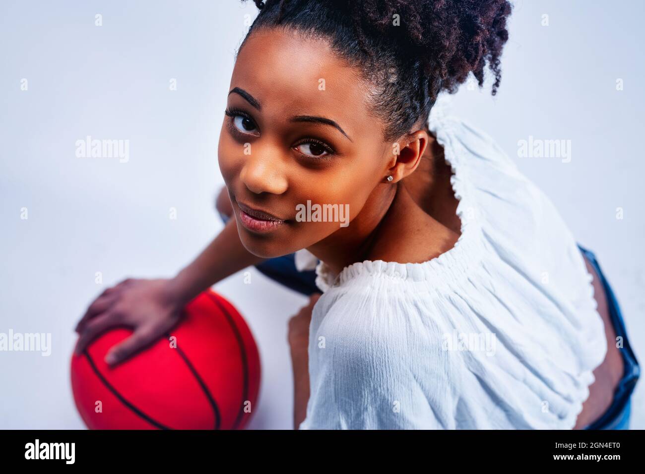 Sporty young Black woman looking up at the camera as she poses crouched ...