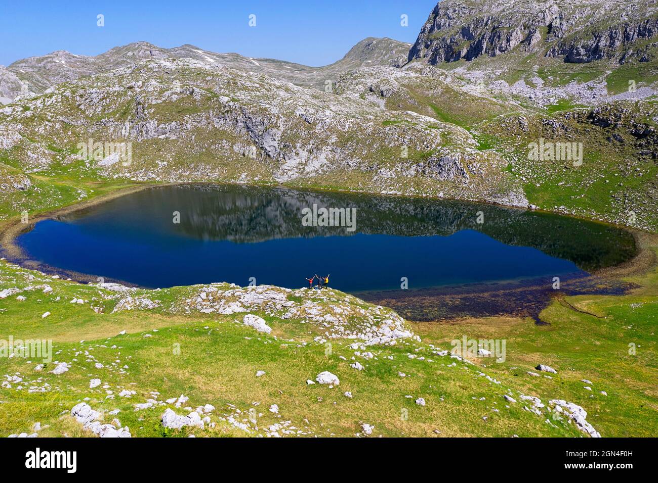 Aerial view od 2 hikers above idyllic alpine manito lake in the in ...