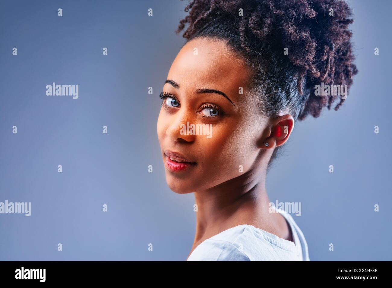 Beautiful young Black woman with blue eyes and curly hair piled high on ...