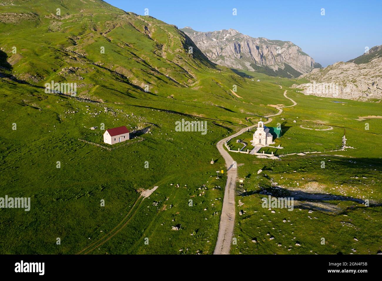 Aerial view of a windy road through beautiful landscape full of flowers ...