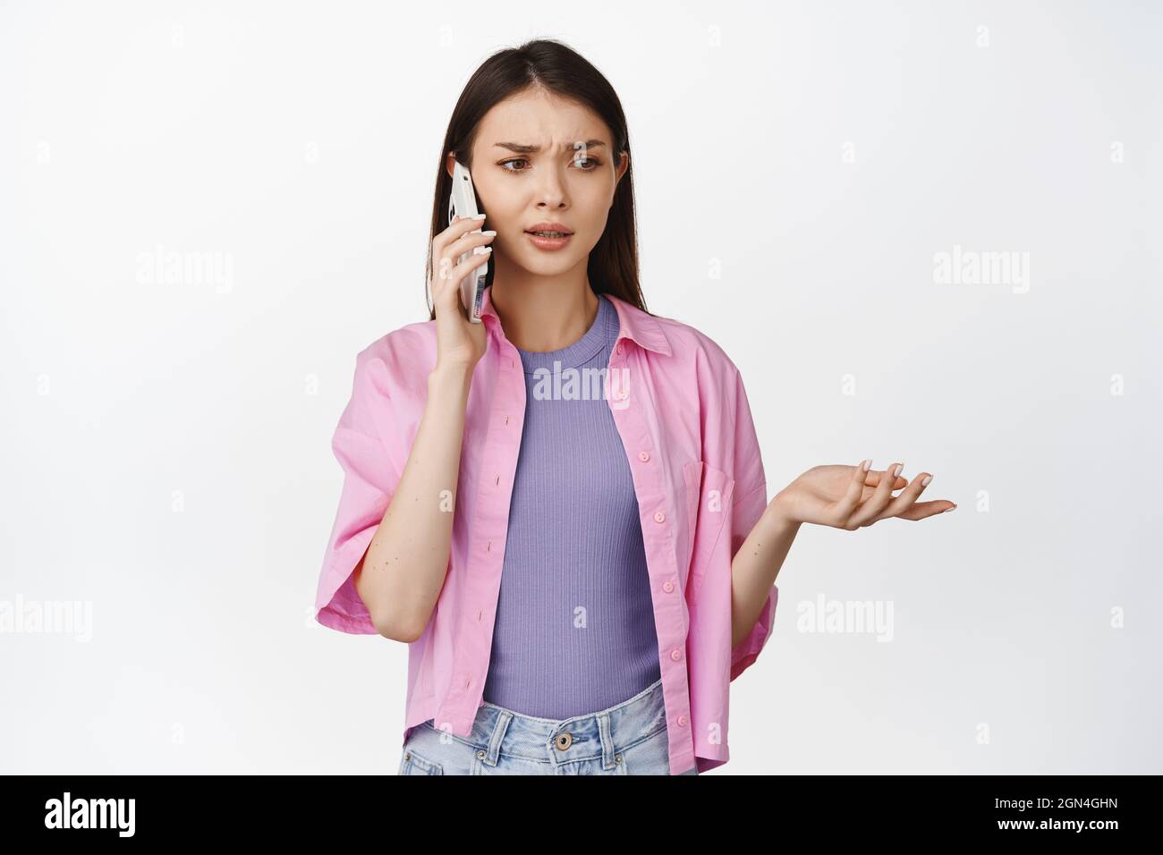 Confused woman talking on mobile phone with puzzled face expression ...