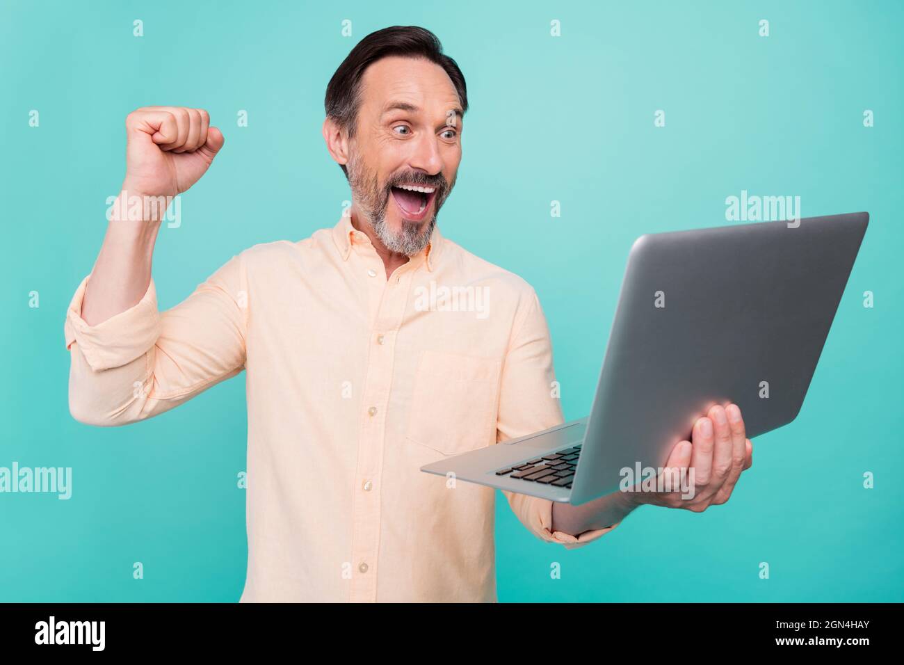 Photo of hooray mature man hand fist look laptop wear peach shirt ...
