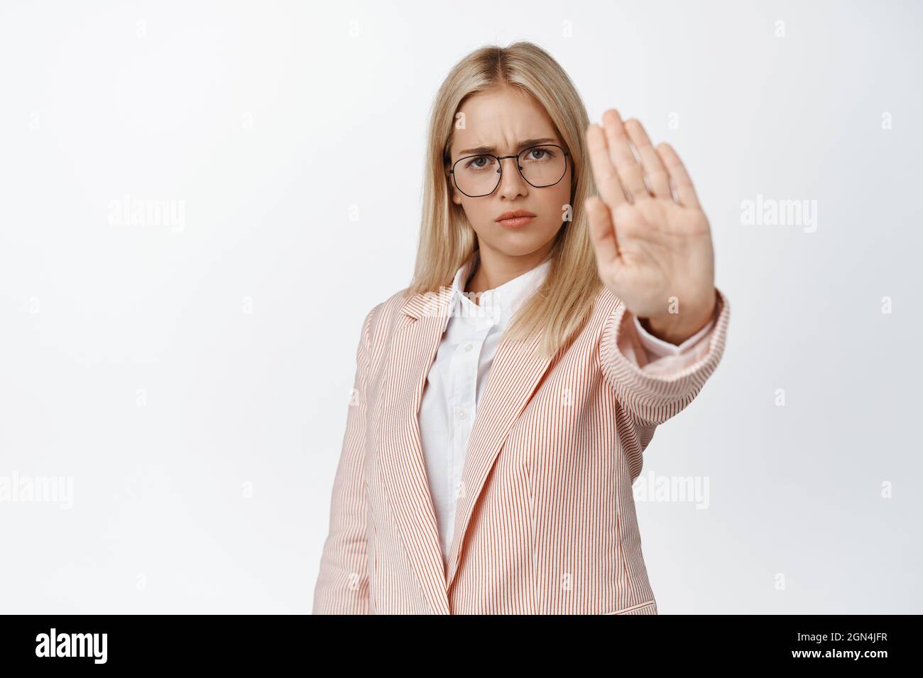 Serious female entrepreneur stretching out hand in stop sign, prohibit ...