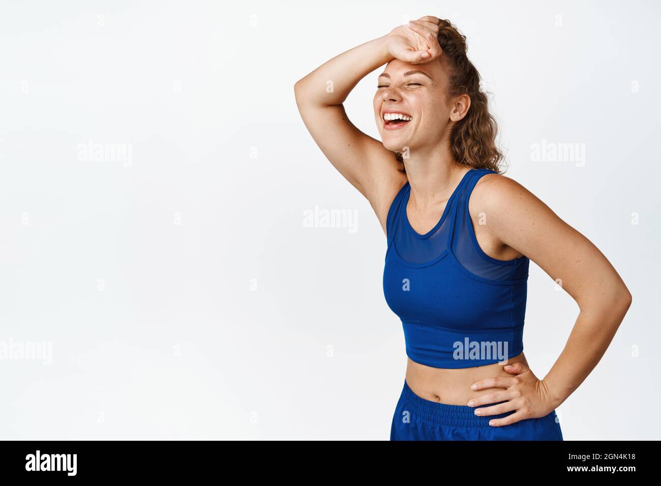 Happy sports woman wipe sweat on forehead and laughing. Fitness girl ...