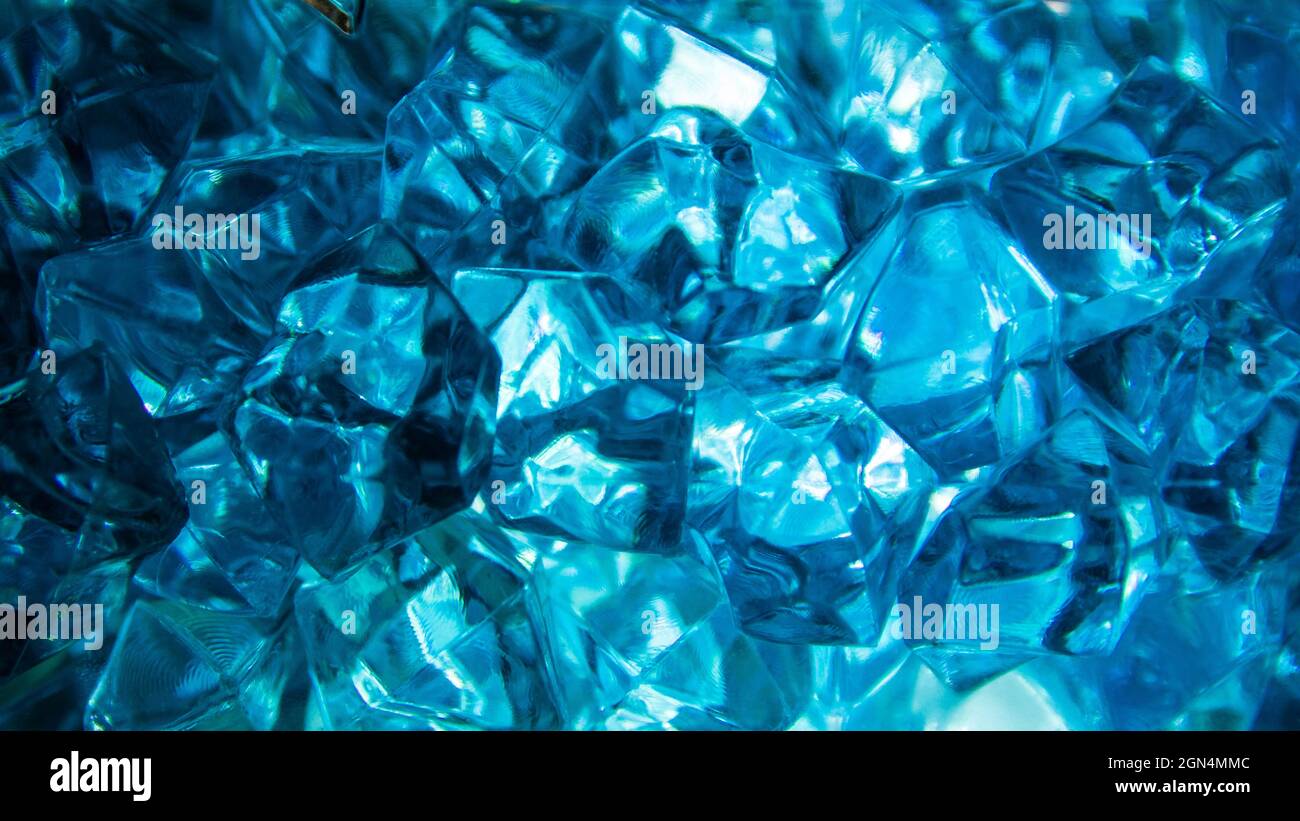 Bright blue crystals made of glass look like gems close-up in the blur ...