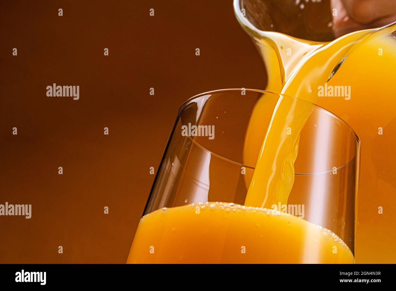 Orange juice pouring into glass Stock Photo - Alamy