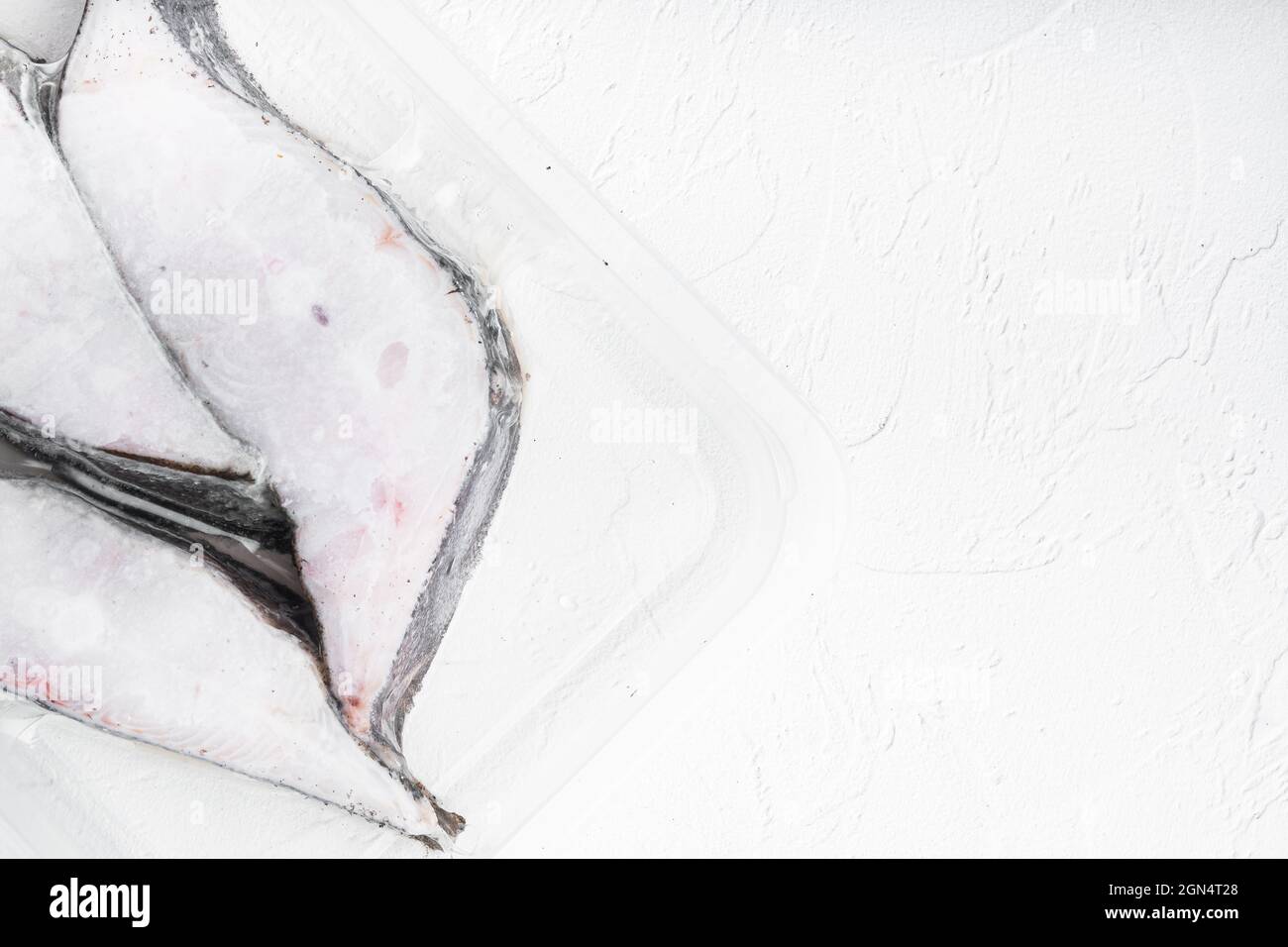 Halibut iced fillet plastic pack set, on white stone table background ...