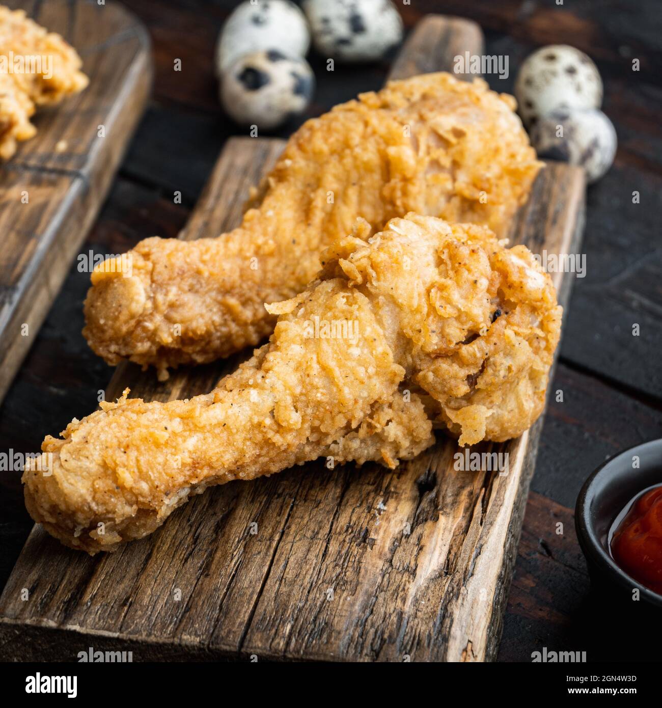 Fried crispy chicken legs, drumstick parts on old dark wooden table ...